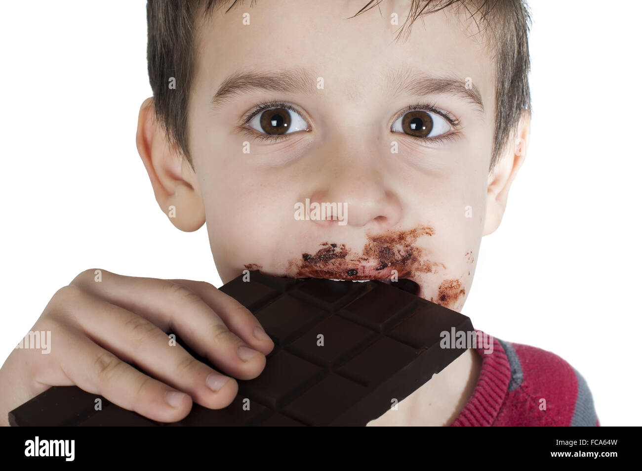 Smiling little boy eating chocolate Stock Photo - Alamy