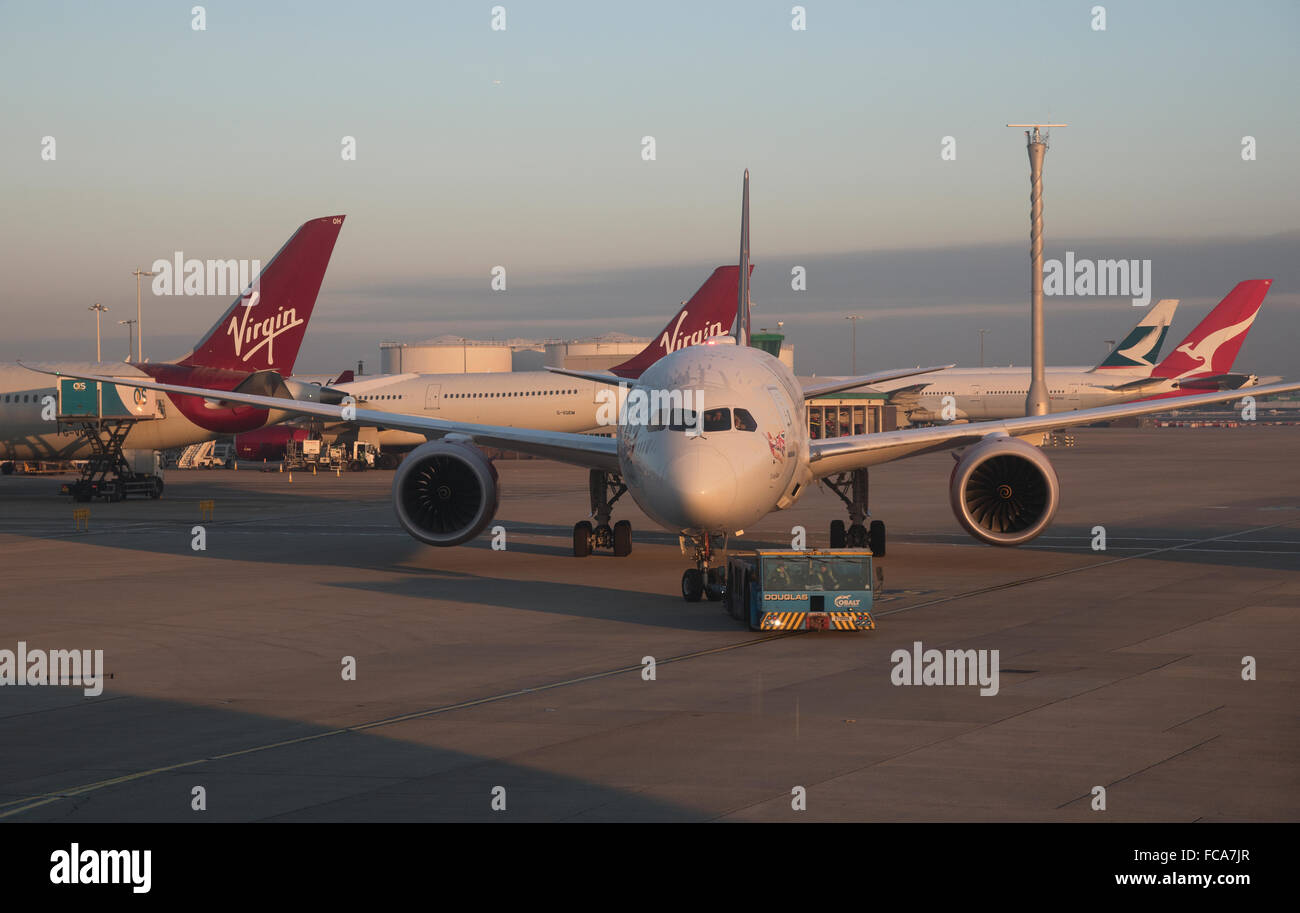 Passenger jet being moved using an aircraft tractor at Heathrow London ...