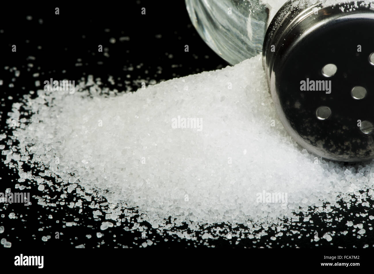 Salt on black background Stock Photo - Alamy