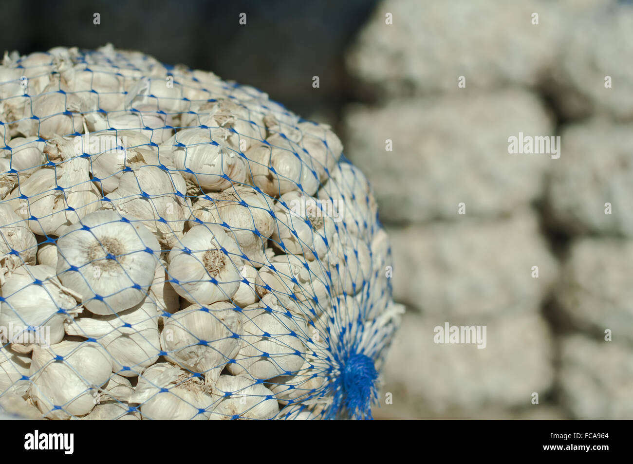 Mesh bag with garlic Stock Photo - Alamy