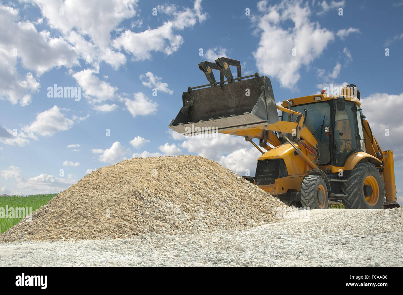 Excavator to a pile of rubble Stock Photo - Alamy