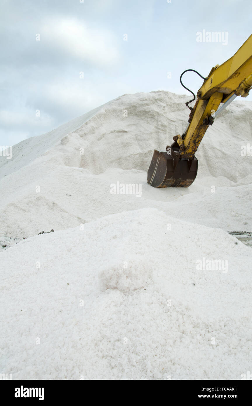 Excavator digging pile salt Stock Photo - Alamy