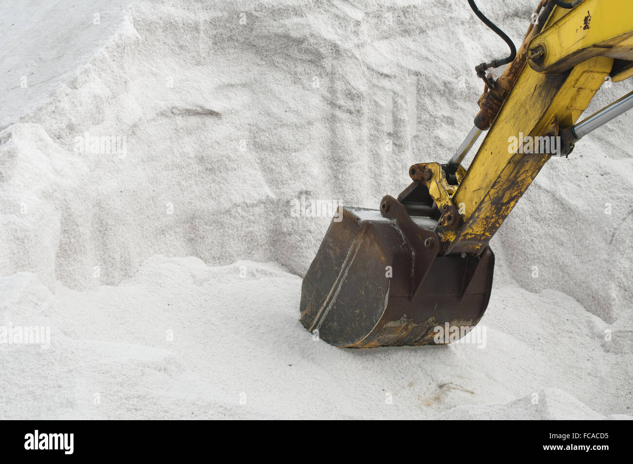 Excavator digging pile salt Stock Photo - Alamy