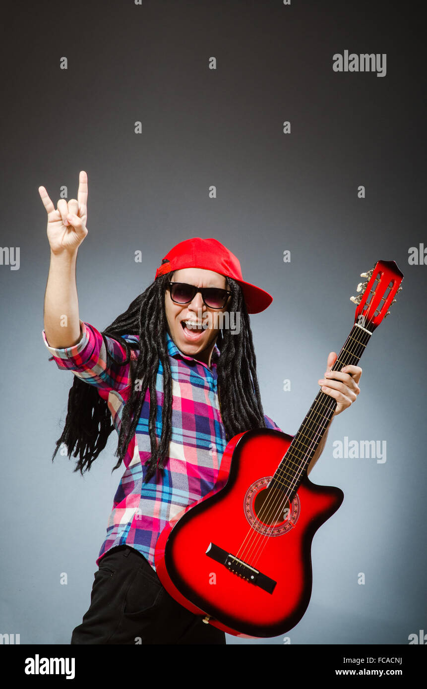 Funny man playing guitar in musical concept Stock Photo - Alamy