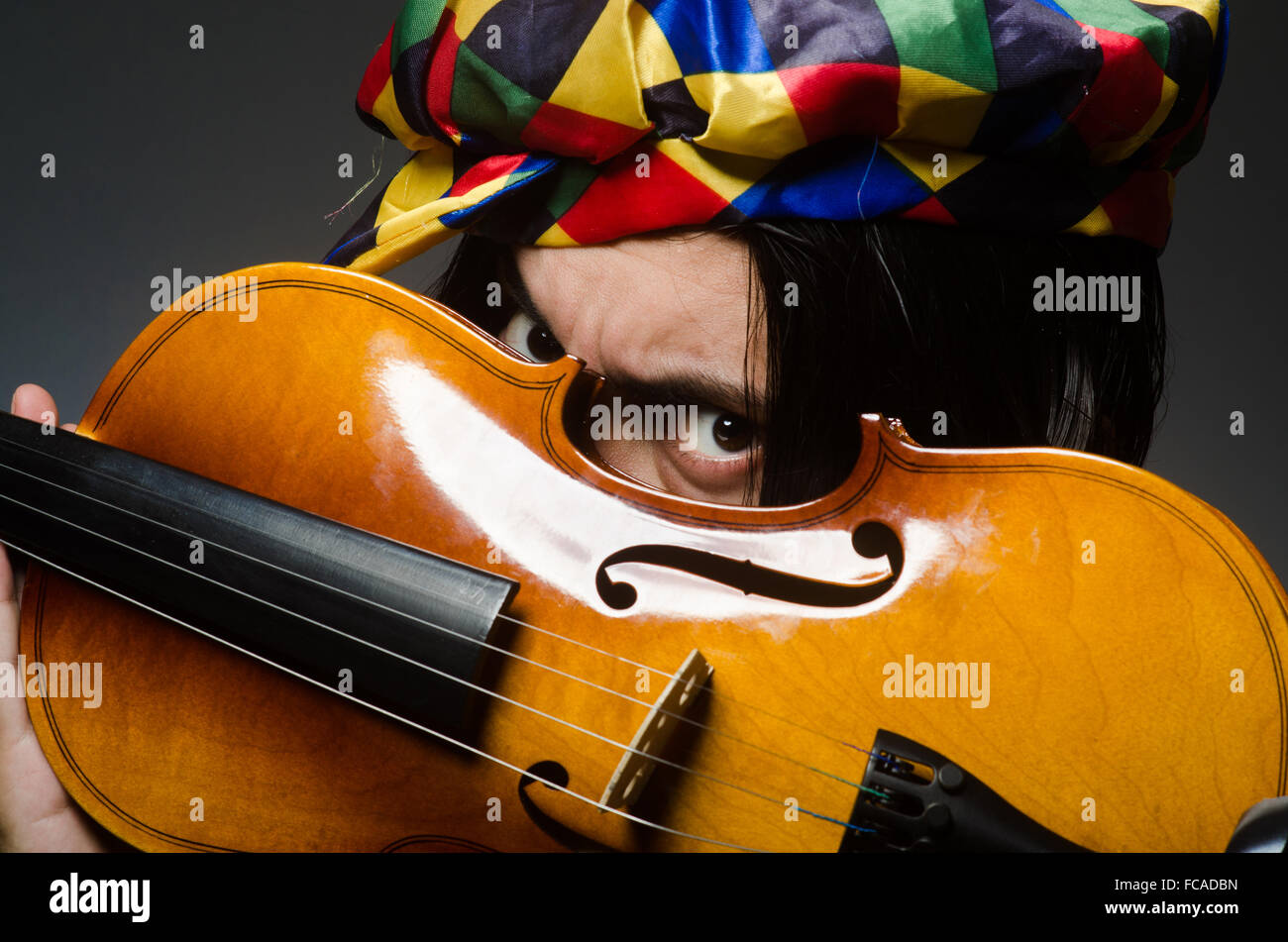 Funny violin clown player in musical concept Stock Photo - Alamy