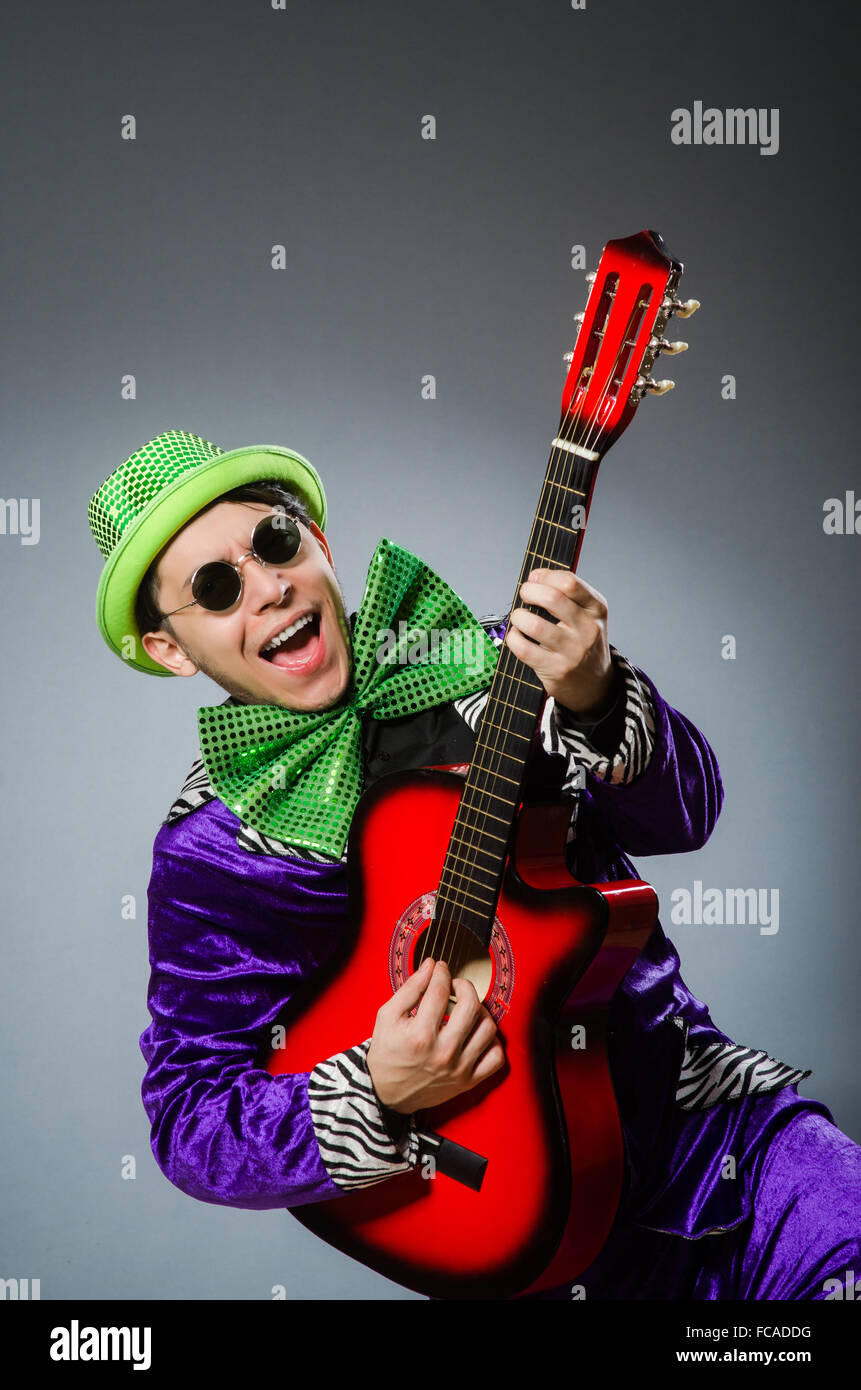 Funny man playing guitar in musical concept Stock Photo - Alamy