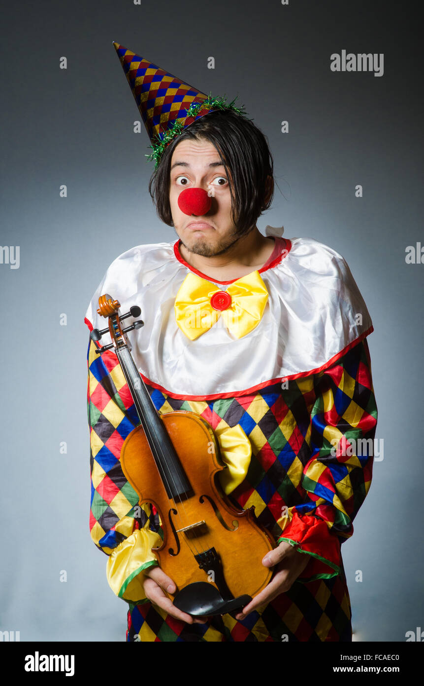 The funny violin clown player in musical concept Stock Photo - Alamy