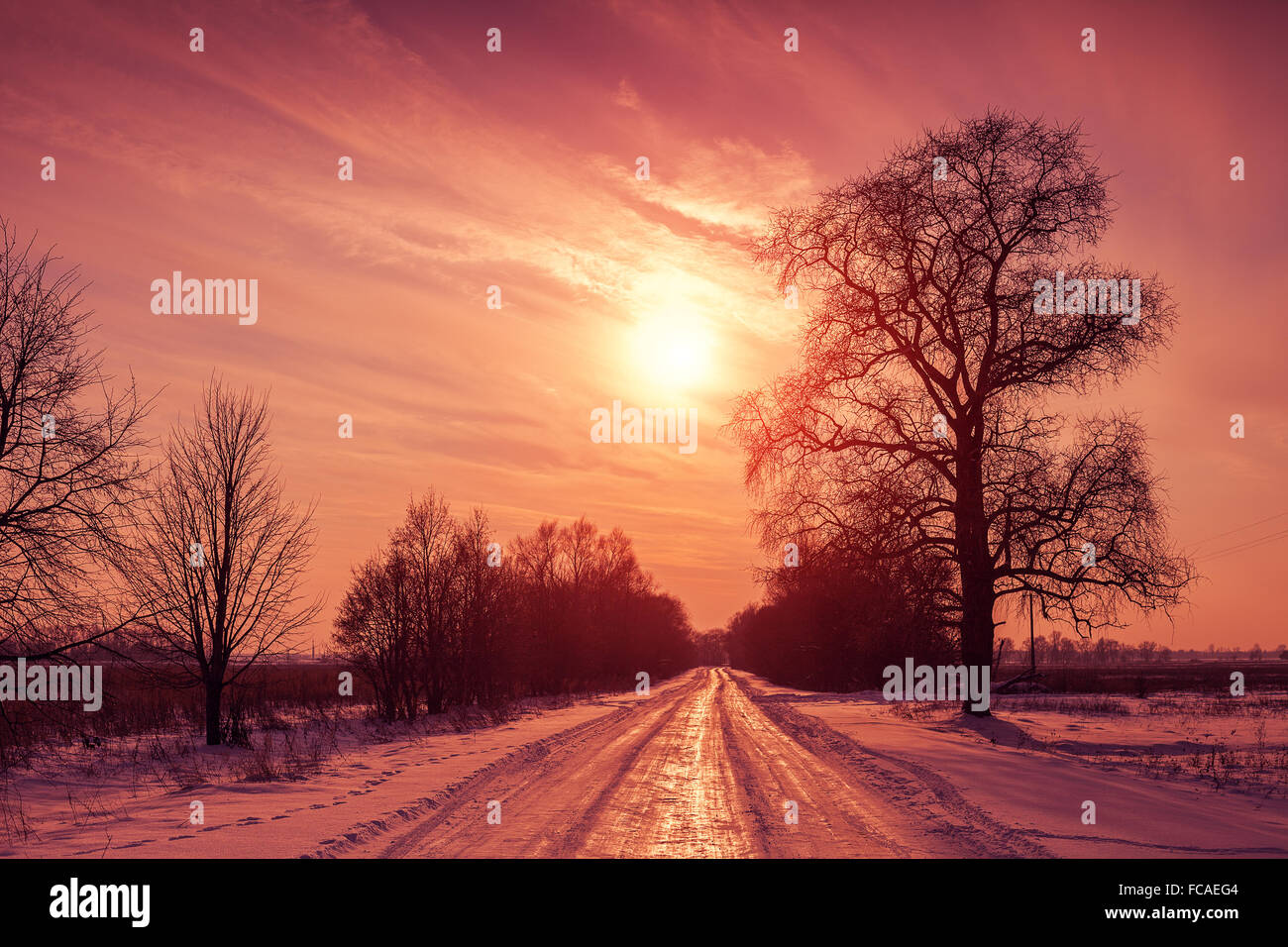 Sunset over snowy road Stock Photo - Alamy