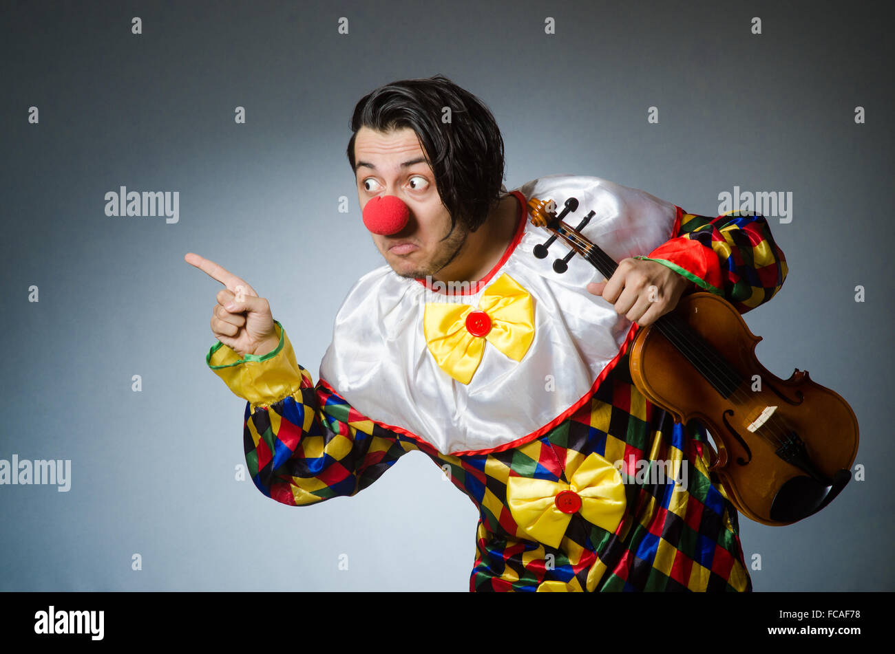 Funny violin clown player in musical concept Stock Photo - Alamy