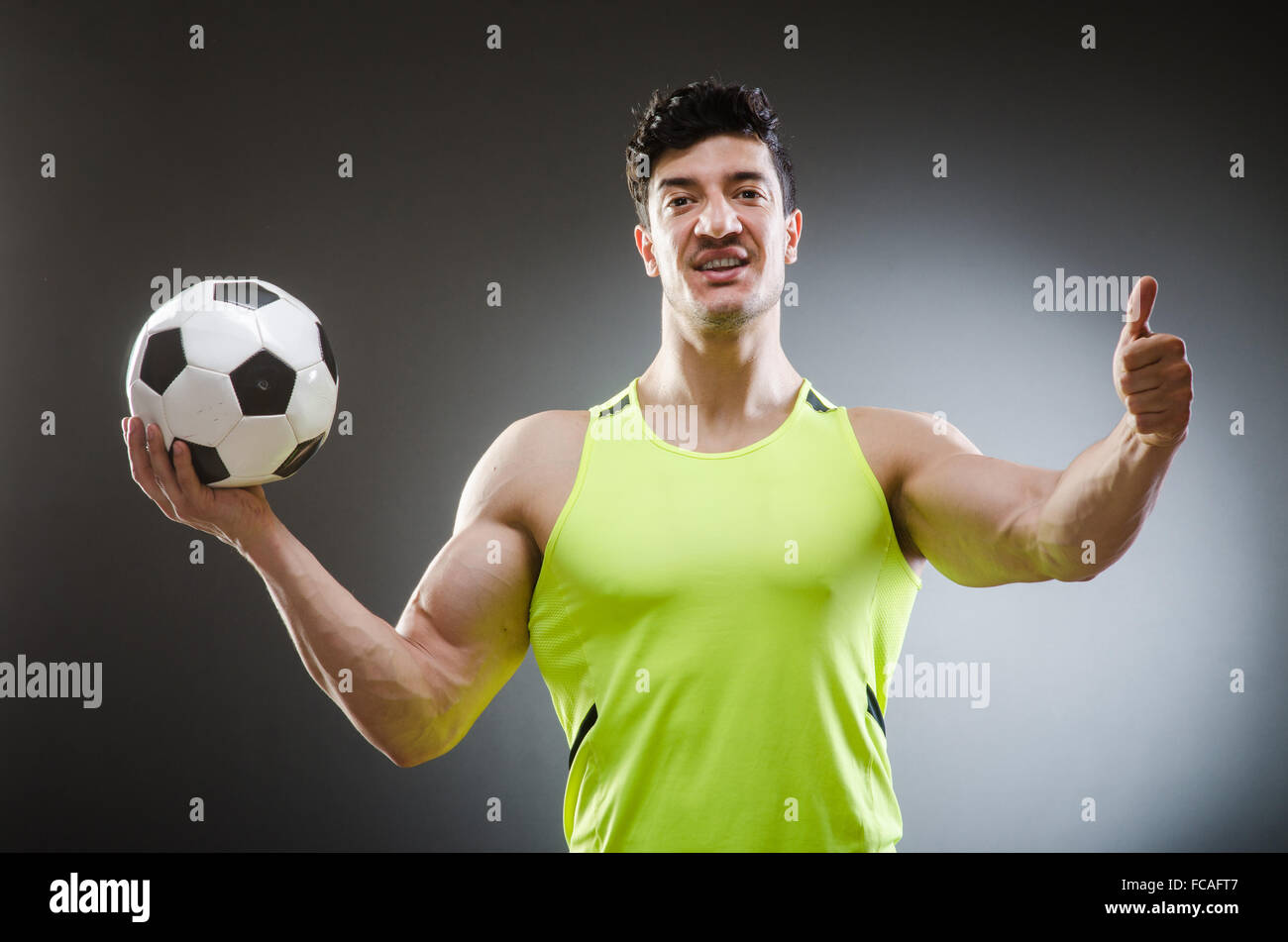 Muscular man with football ball Stock Photo - Alamy
