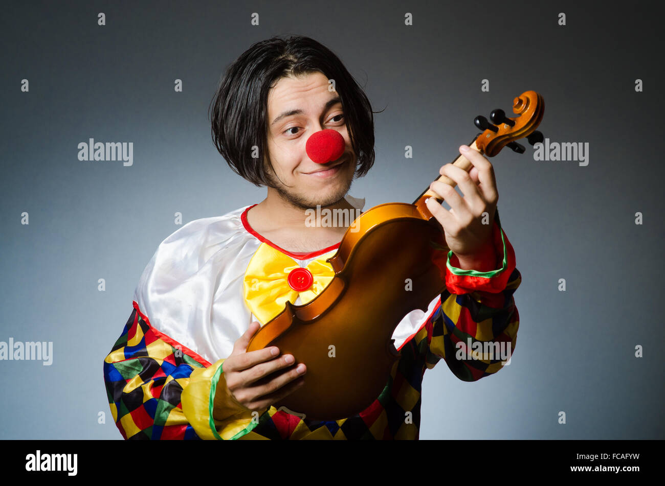 The funny violin clown player in musical concept Stock Photo - Alamy