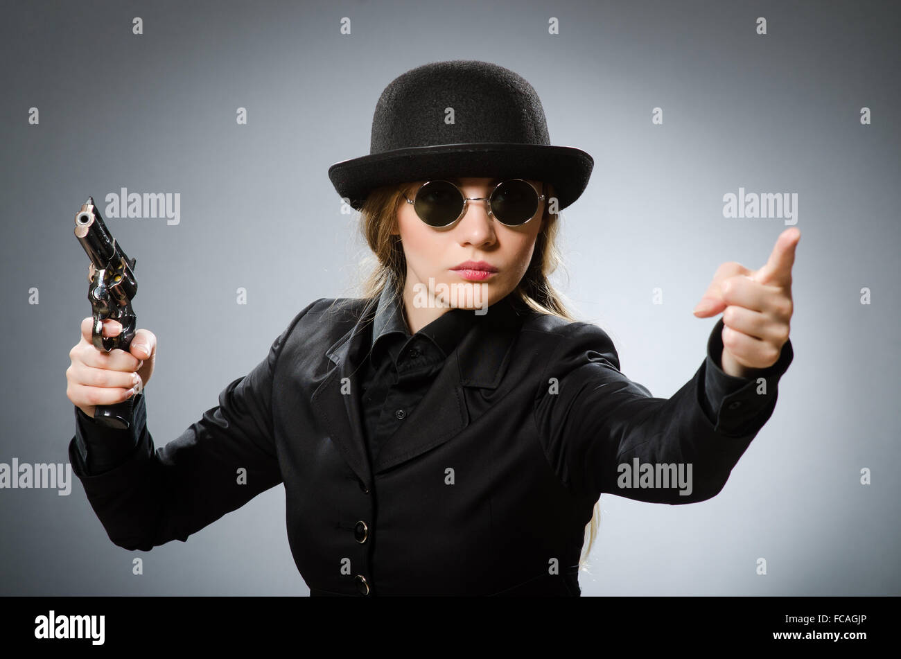 Female spy with weapon against gray Stock Photo - Alamy Female spy with weapon against gray Stock Photo - Alamy