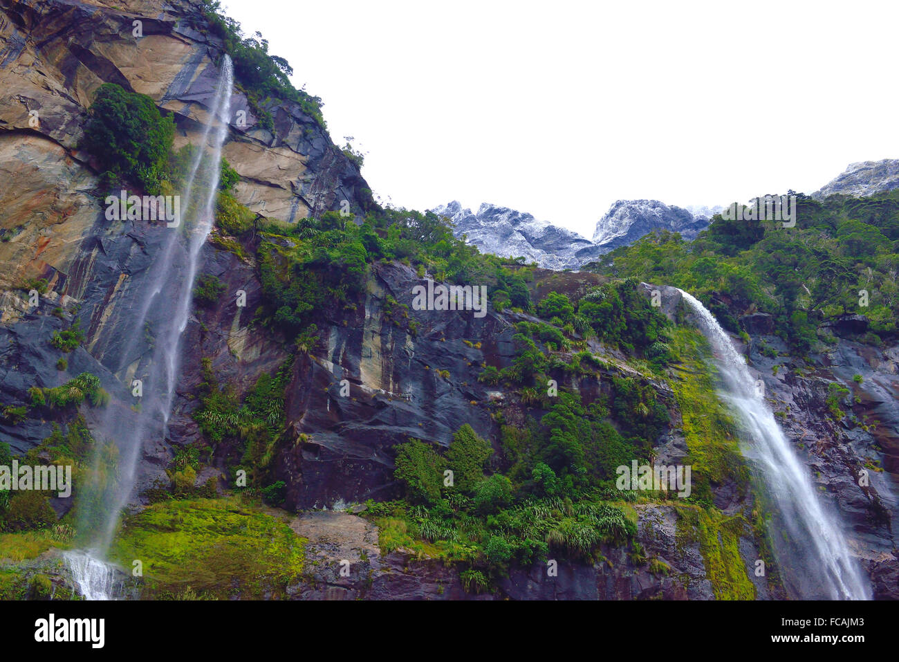 Water cascading over the plateaus of sheer rock faces in the fjords ...