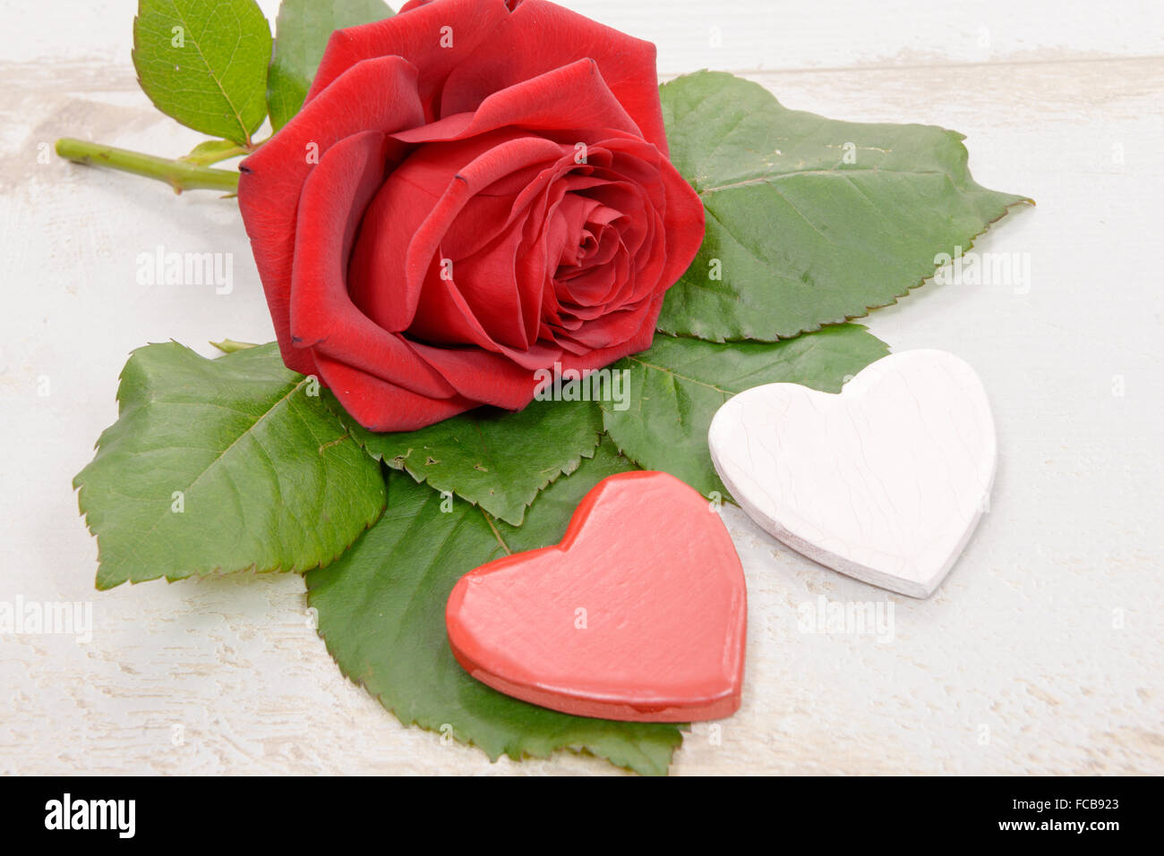 a red rose and two wooden heart Stock Photo - Alamy
