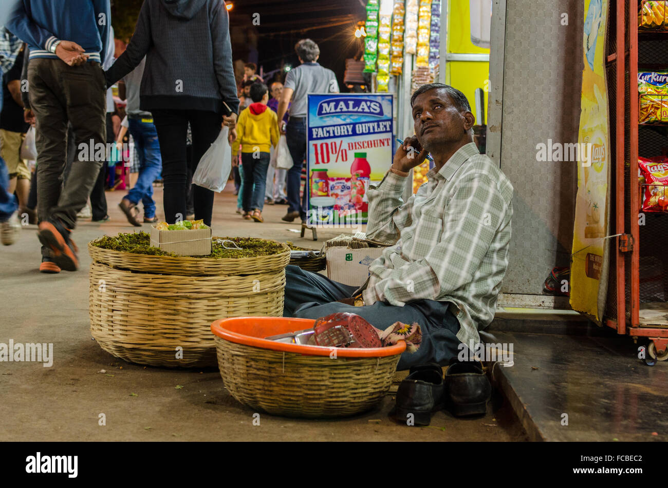 Poor Indian roadside seller lost in thoughts, thinking, sitting on Main ...