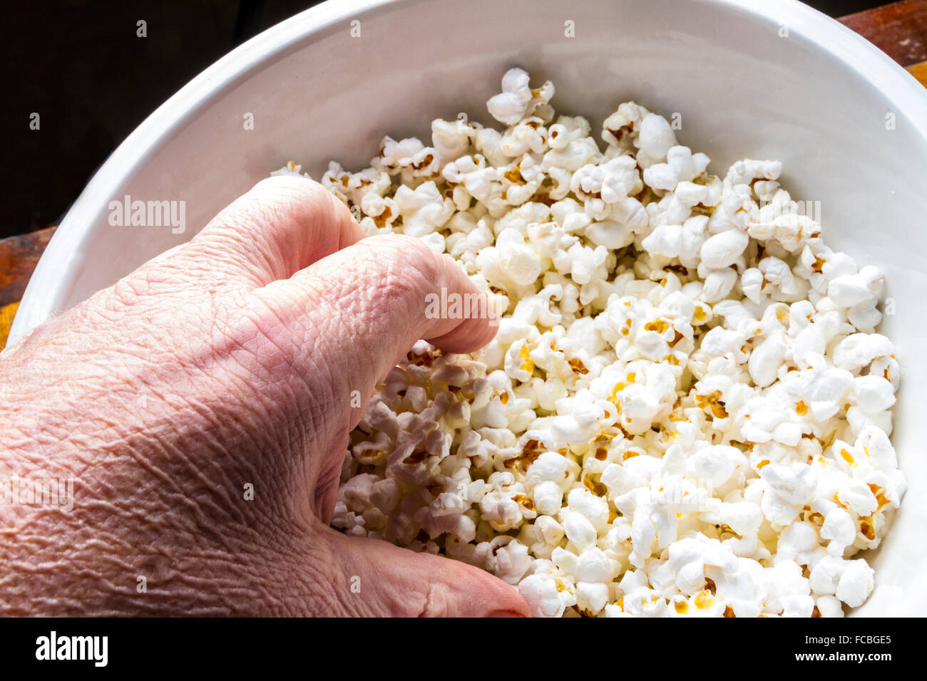 Hand reaching bowl white popcorn hi-res stock photography and images ...