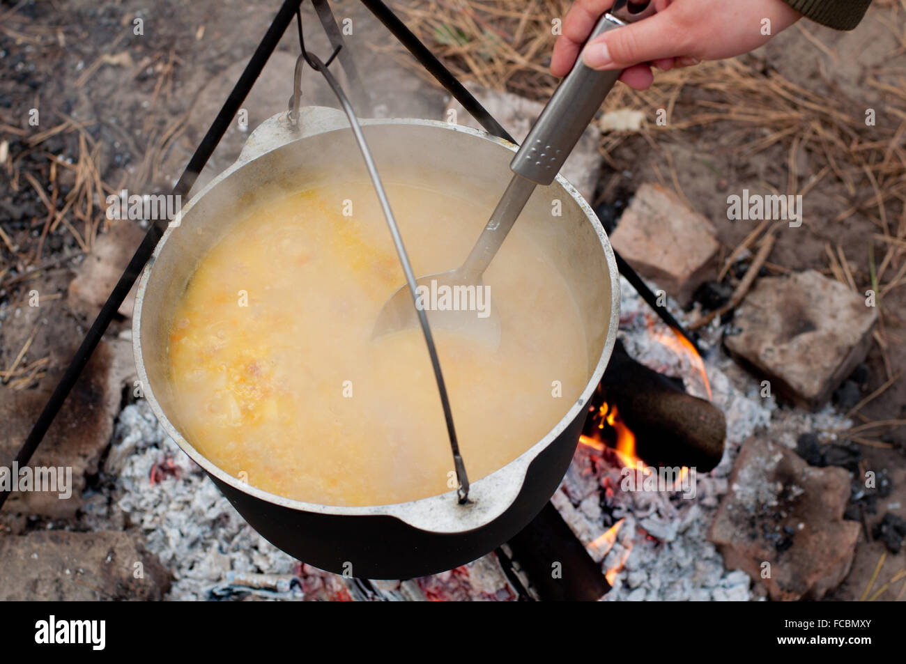 Cooking porridge in black pot on the fire in forest Stock Photo - Alamy