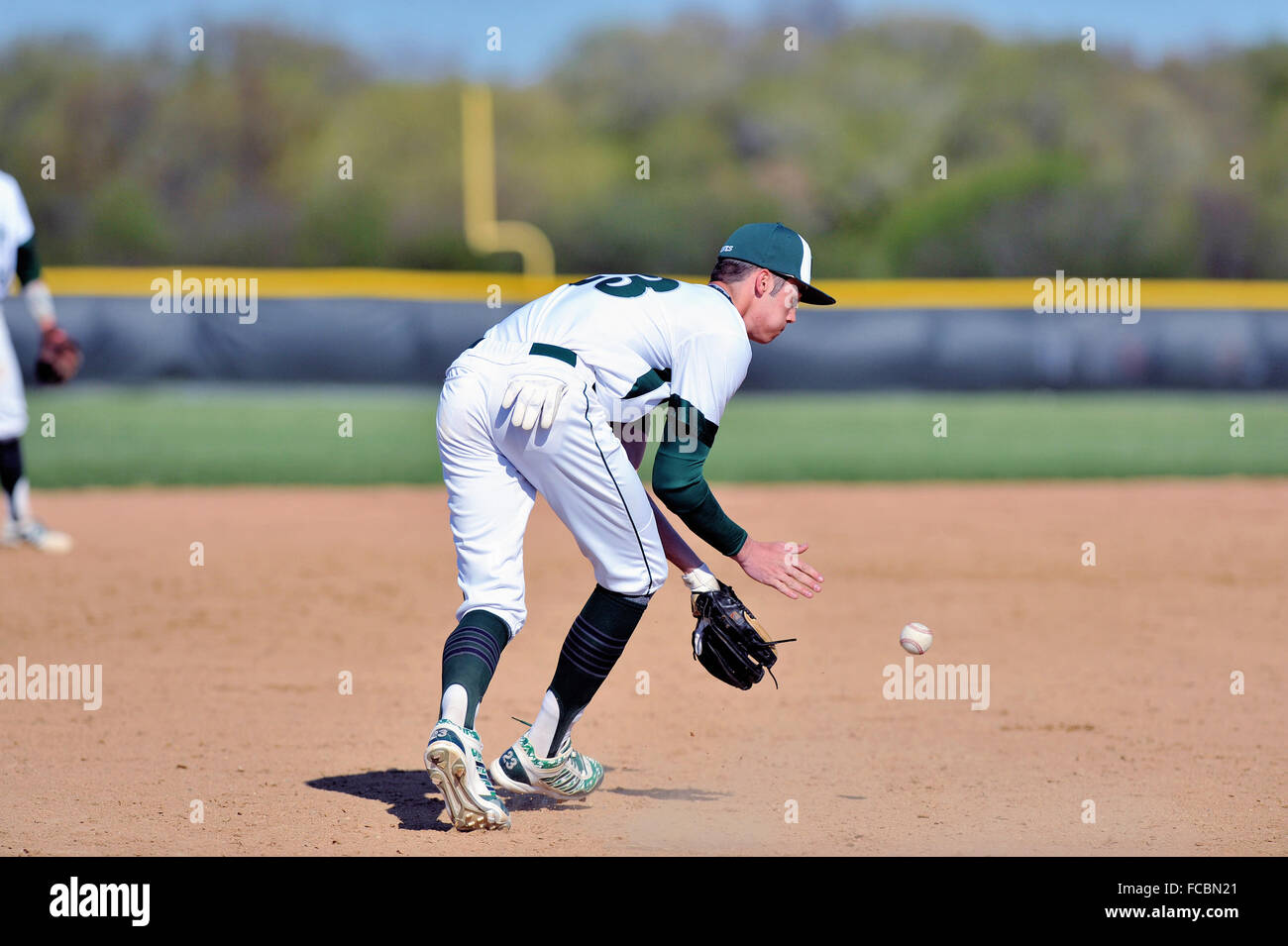 Third baseman moving to his left to make a play on a ground ball prior ...