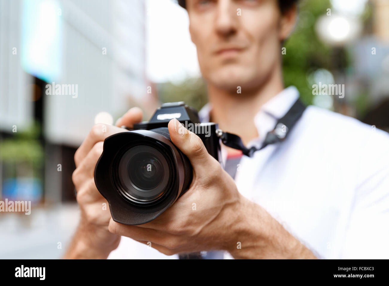 Professional photographer taking picture in city Stock Photo - Alamy