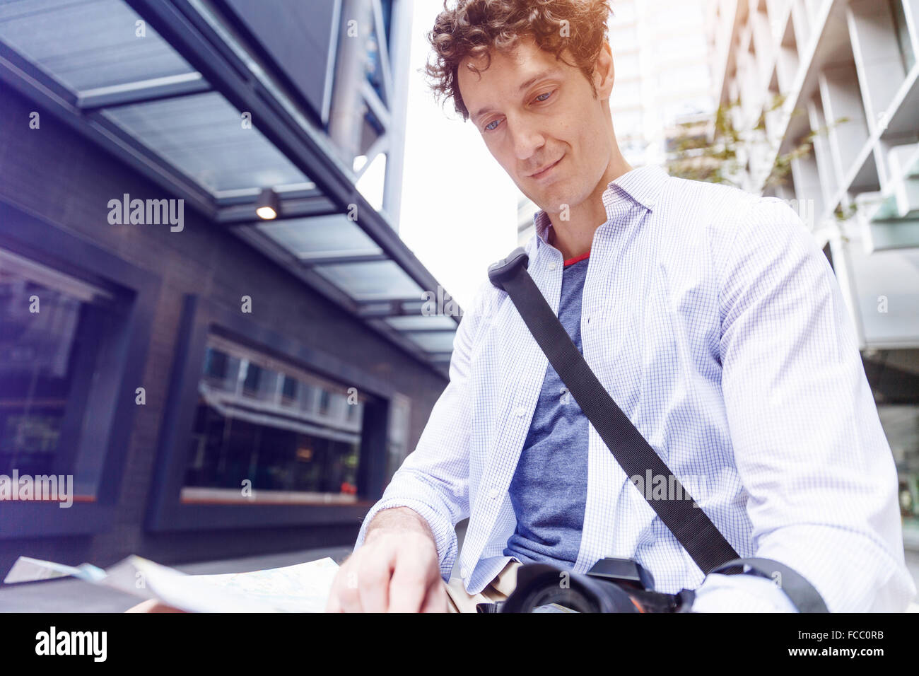 Young male tourist in city with camera and map Stock Photo - Alamy
