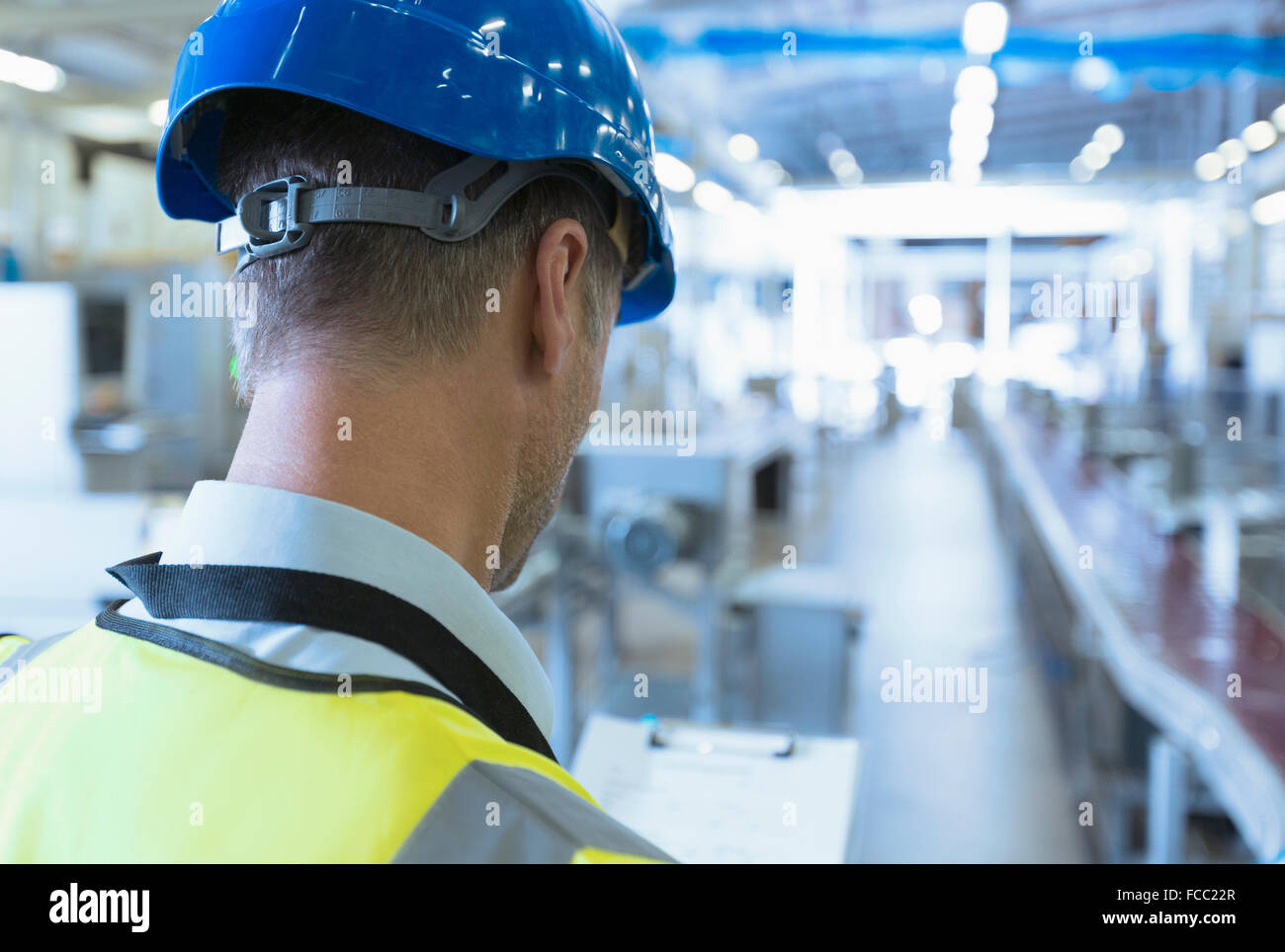 Worker with clipboard in factory Stock Photo - Alamy