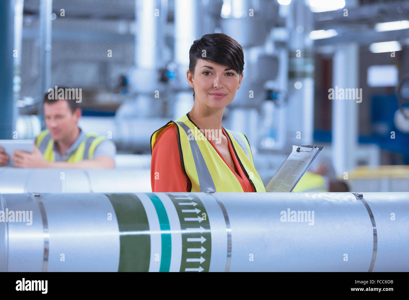 Portrait confident female worker with clipboard in factory Stock Photo ...