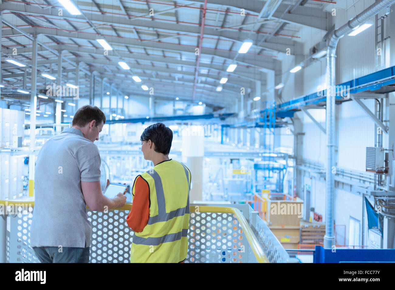 Workers with digital tablet on platform above factory Stock Photo - Alamy
