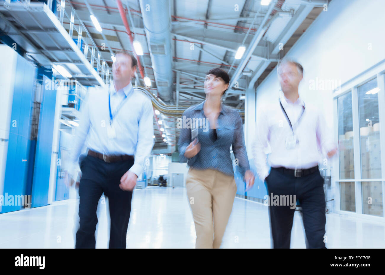 Business people walking in factory corridor Stock Photo - Alamy