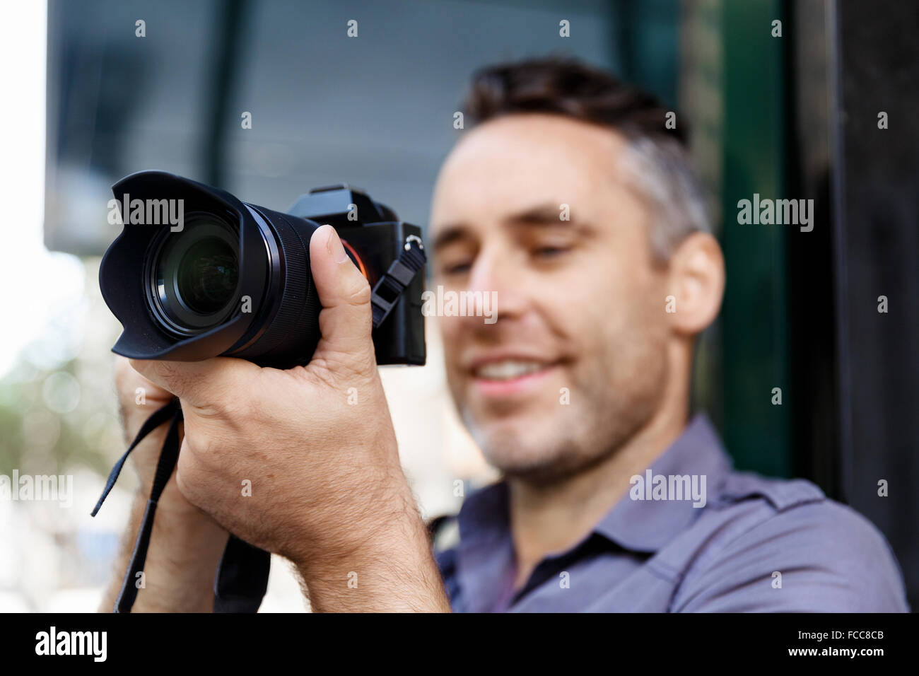 Professional photographer taking picture in city Stock Photo - Alamy