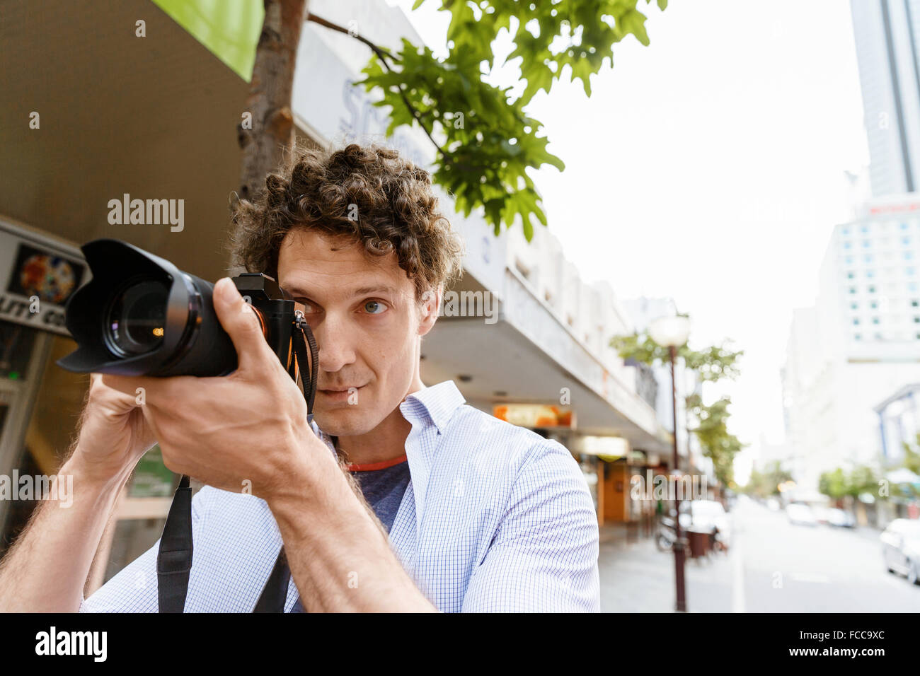 Professional photographer taking picture in city Stock Photo - Alamy