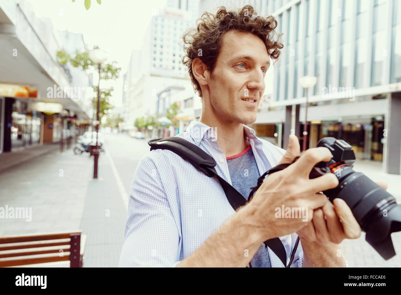 Professional photographer taking picture in city Stock Photo - Alamy