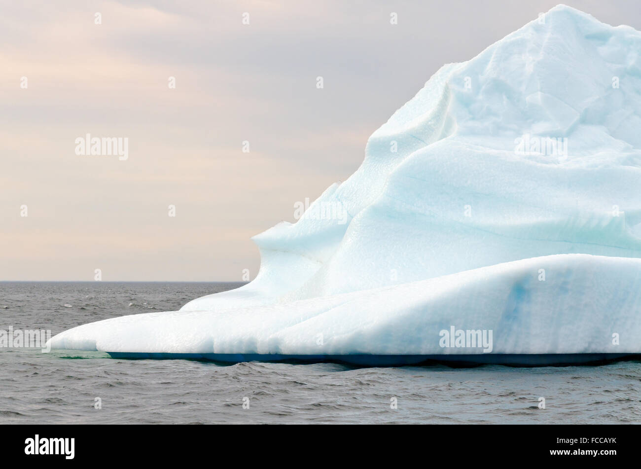 Bright white iceberg on dark water and rock background Stock Photo - Alamy