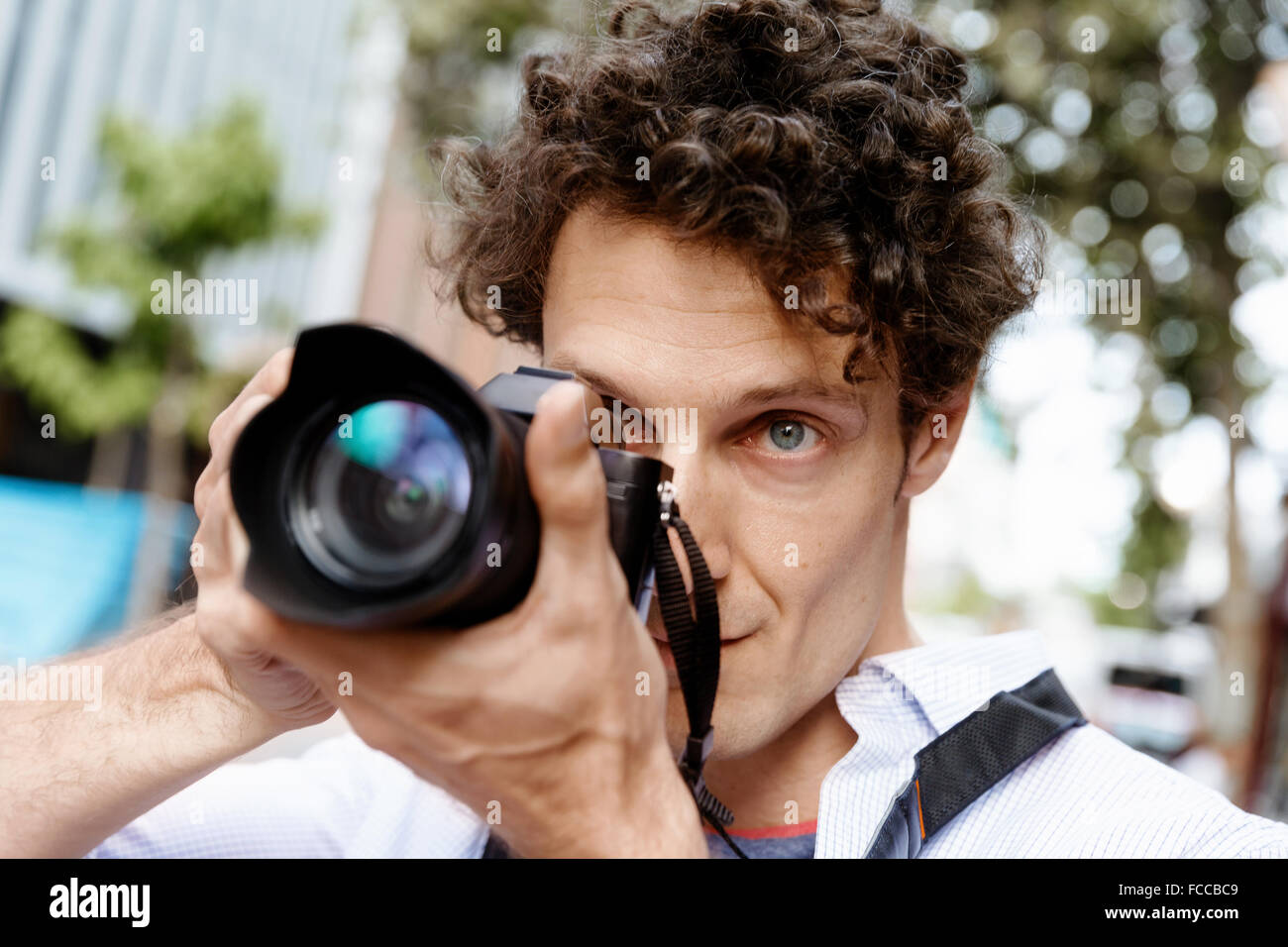 Professional photographer taking picture in city Stock Photo - Alamy