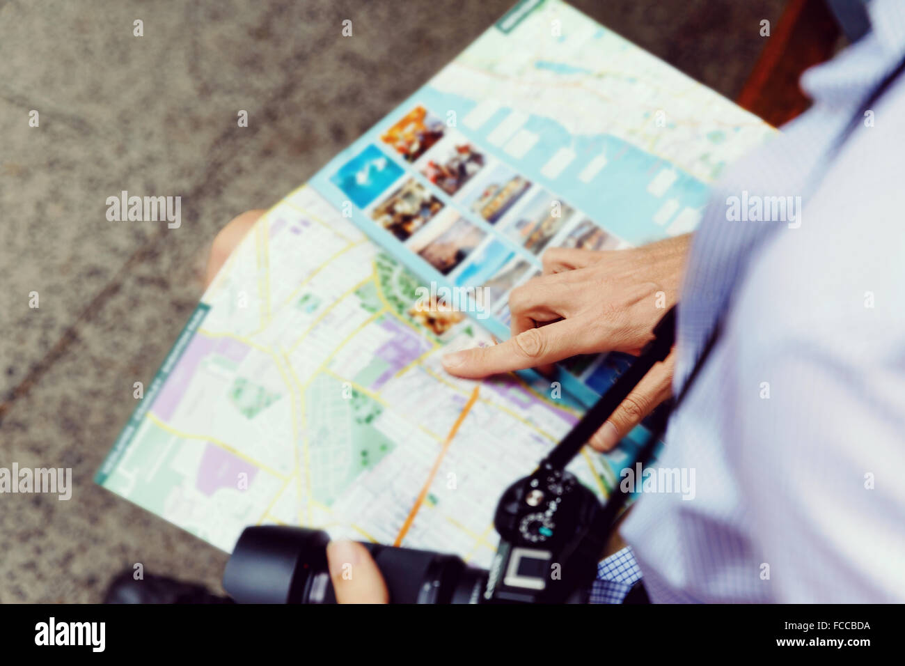 Happy male tourist in city with camera and map Stock Photo - Alamy