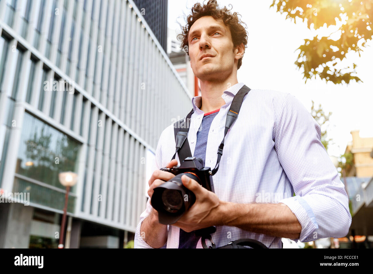 Professional photographer taking picture in city Stock Photo - Alamy