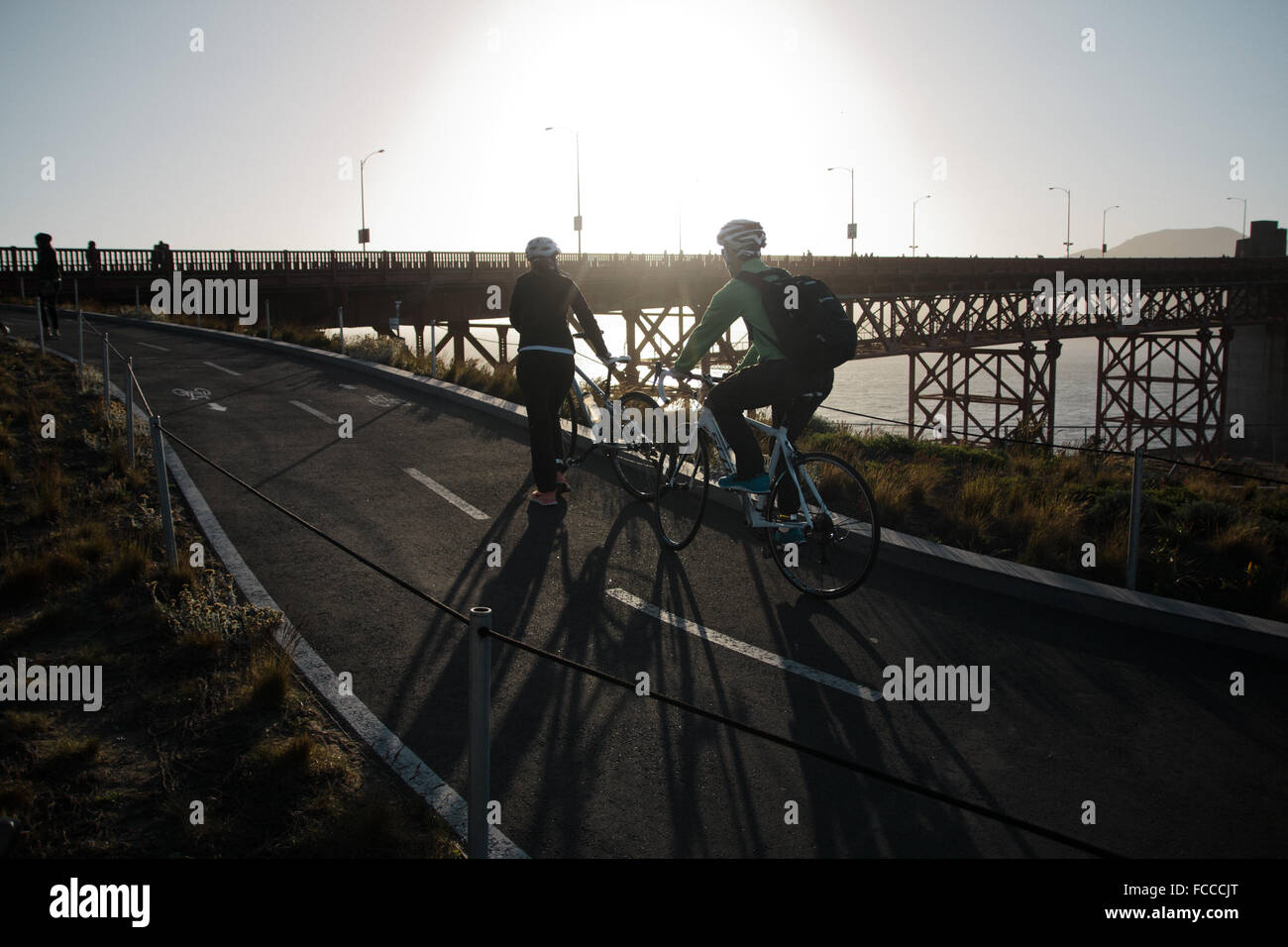 Rear View Of Two People Bicycling On Road Against Clear Sky Stock Photo ...