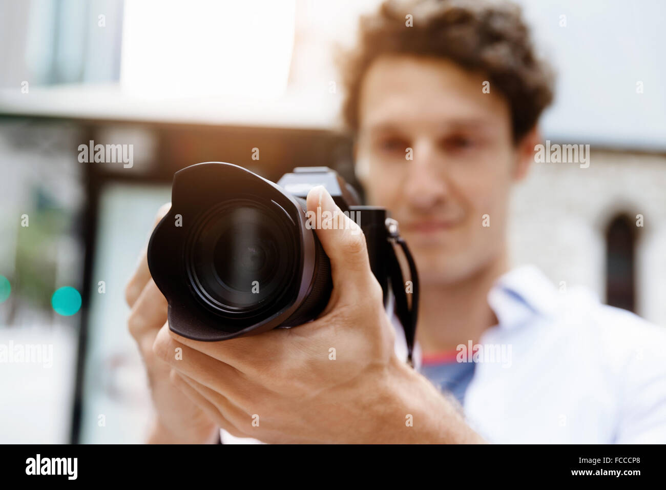 Professional photographer taking picture in city Stock Photo - Alamy