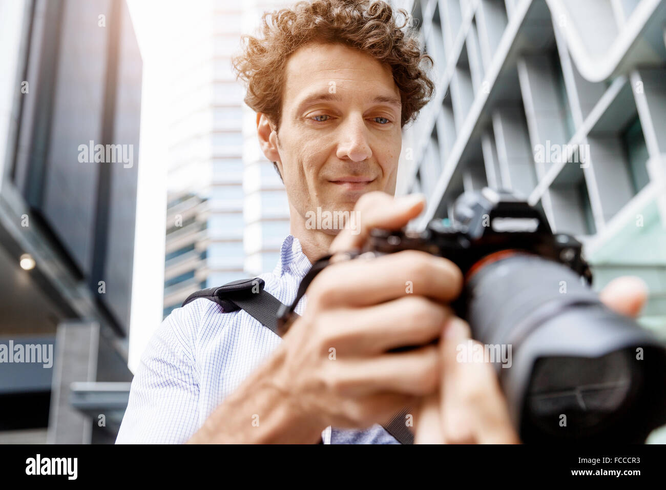 Professional photographer taking picture in city Stock Photo - Alamy