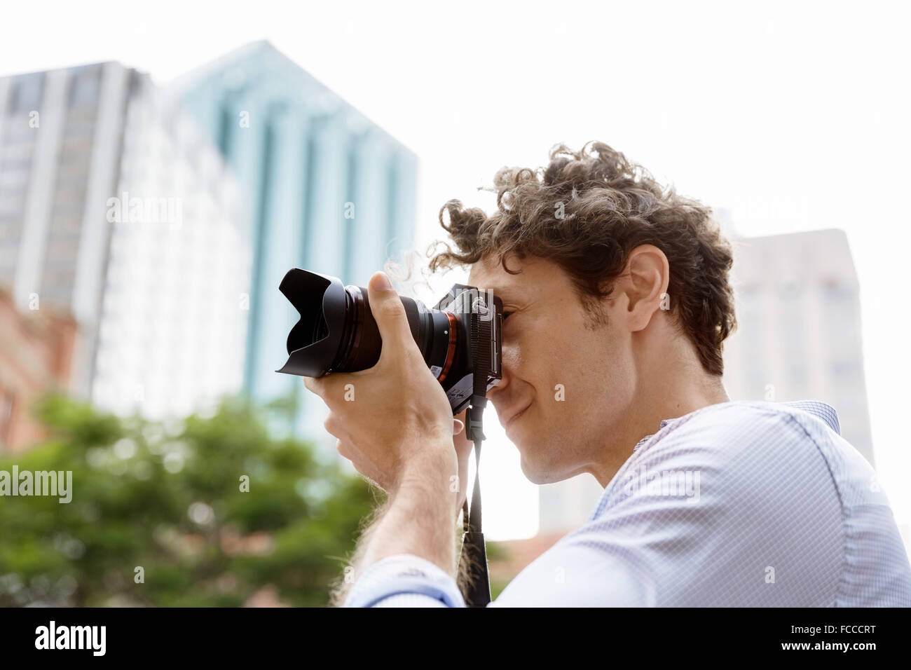 Professional photographer taking picture in city Stock Photo - Alamy