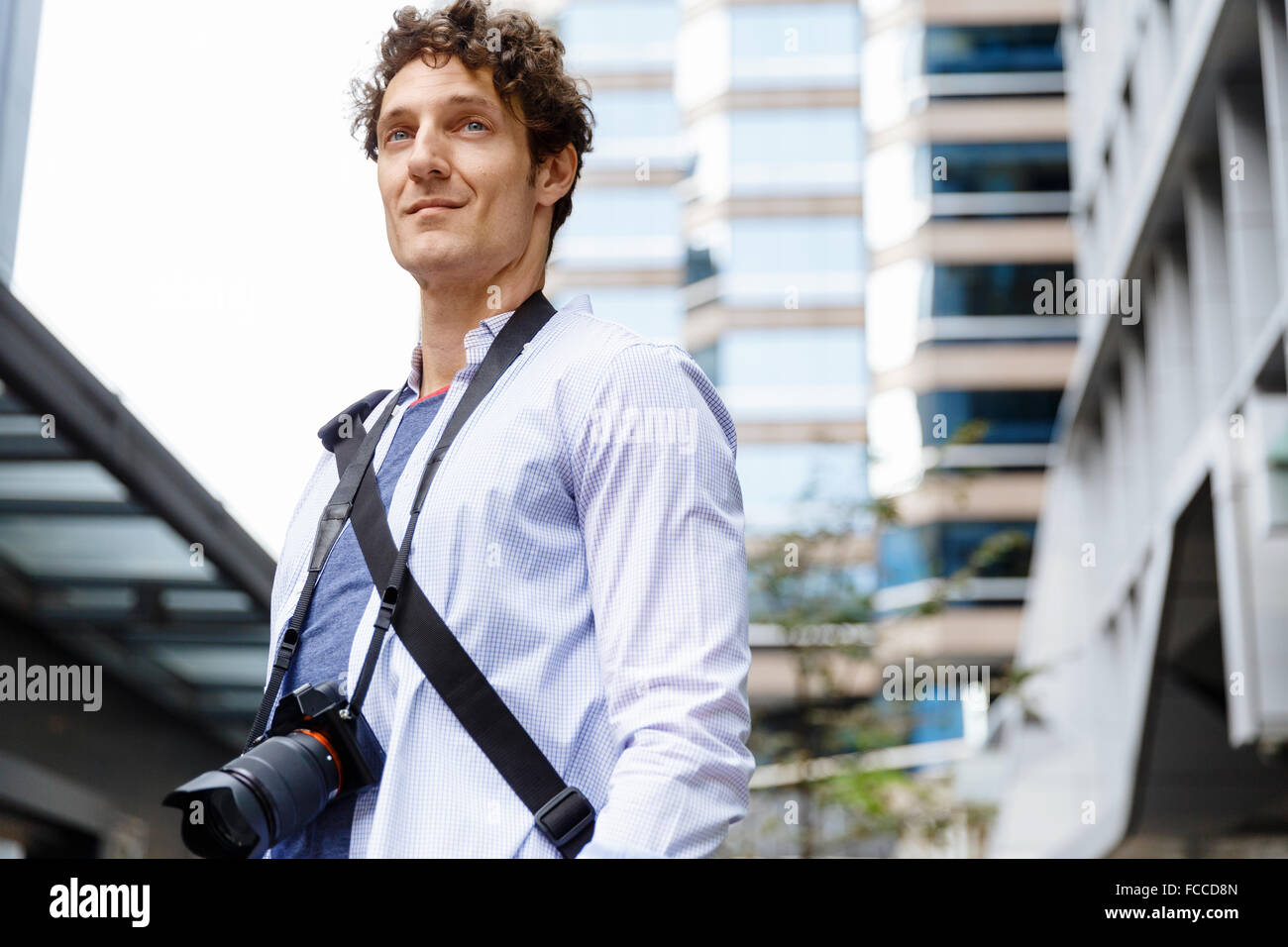 Happy male tourist in city walking with camera Stock Photo - Alamy