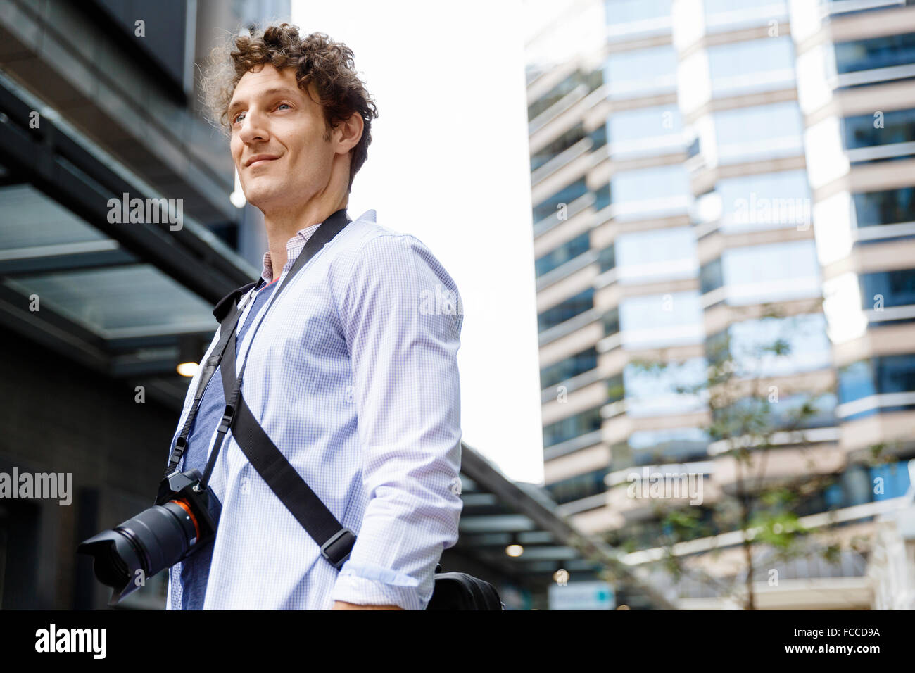 Happy male tourist in city walking with camera Stock Photo - Alamy
