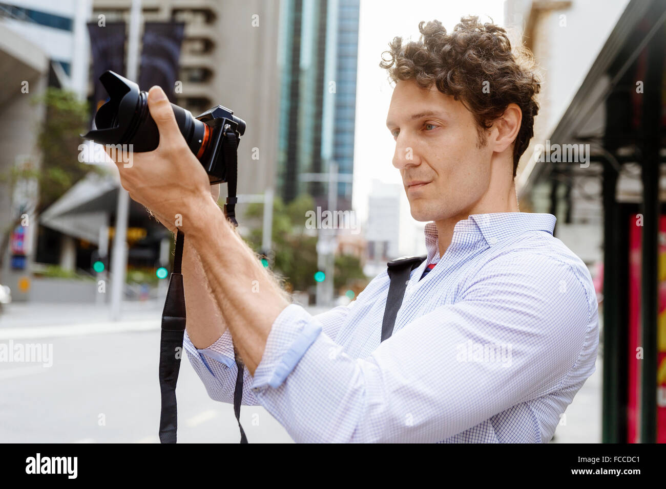 Professional photographer taking picture in city Stock Photo - Alamy