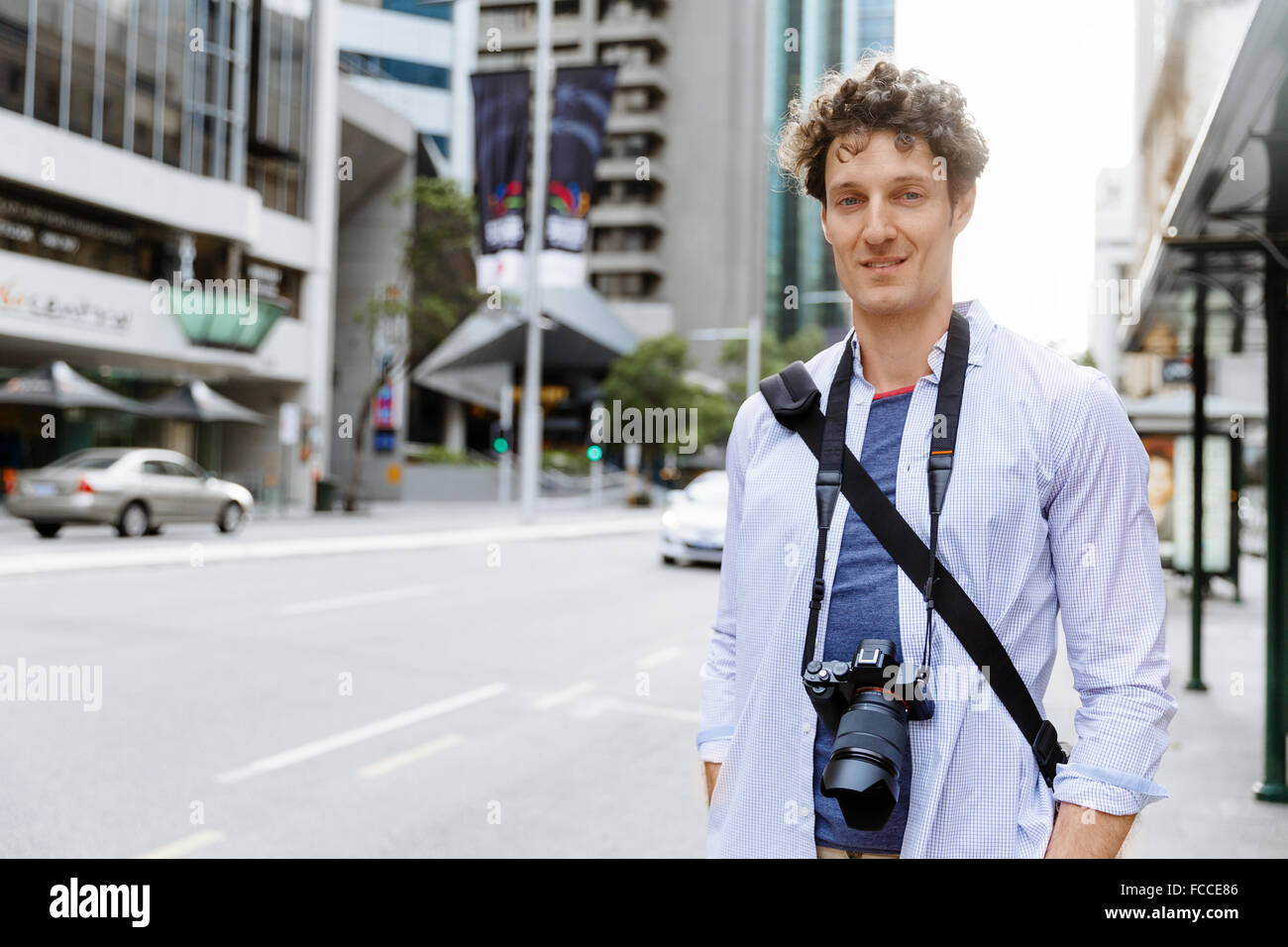 Happy male tourist in city walking with camera Stock Photo - Alamy