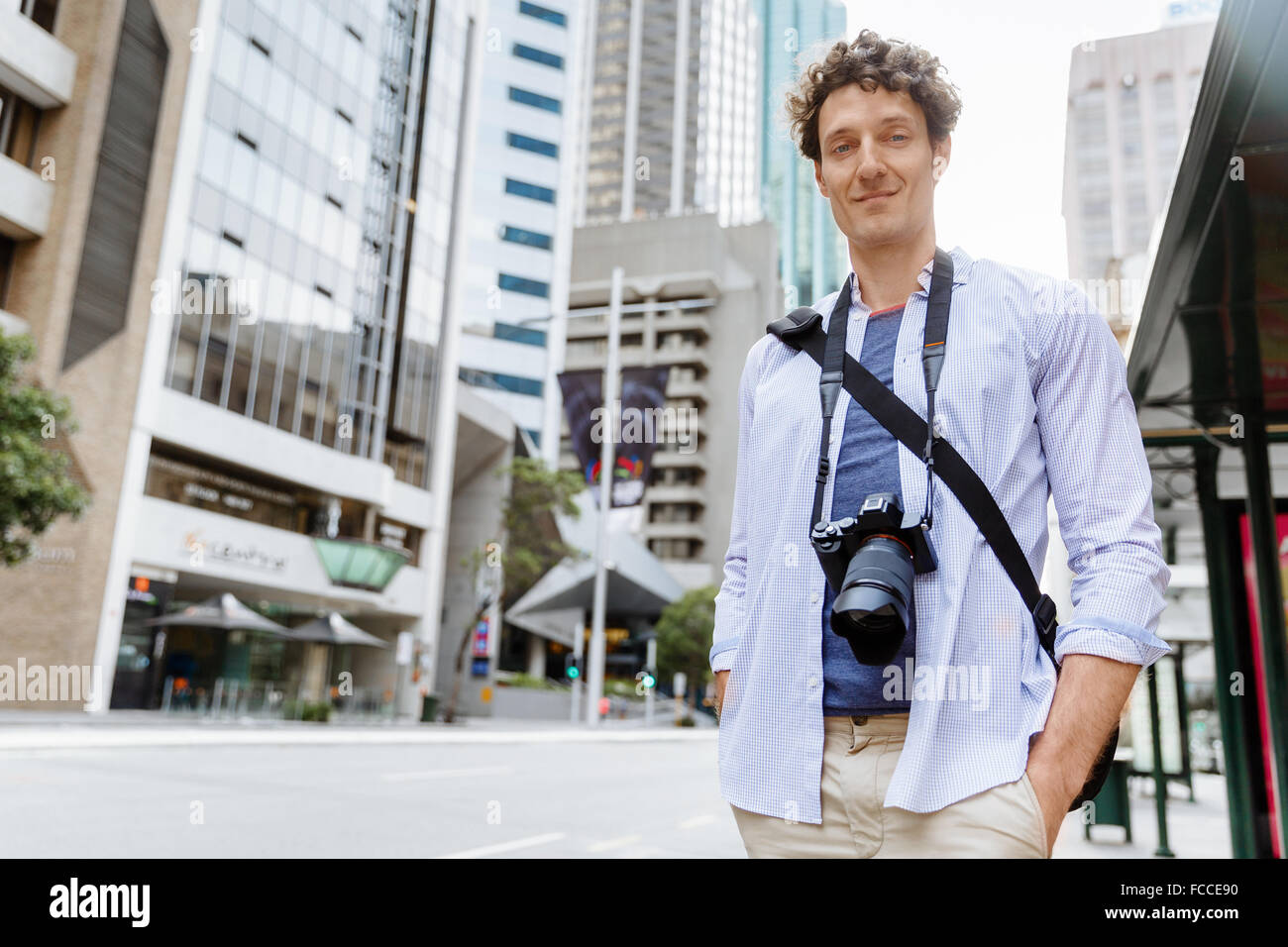 Happy male tourist in city walking with camera Stock Photo - Alamy