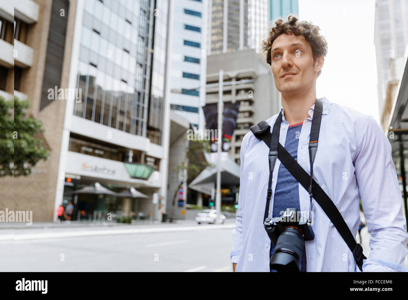 Happy male tourist in city walking with camera Stock Photo - Alamy