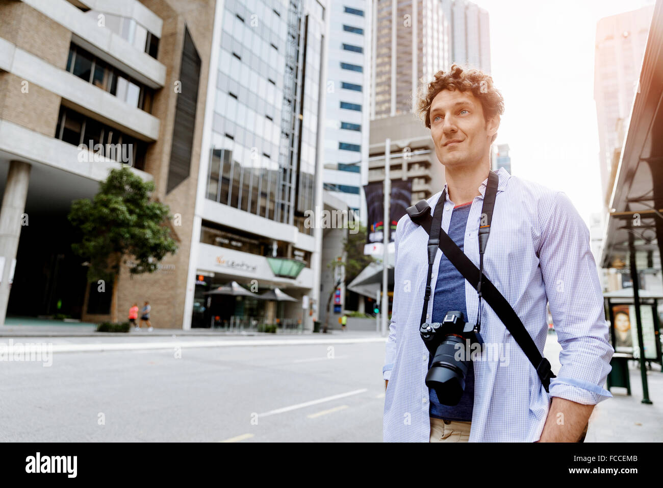 Happy male tourist in city walking with camera Stock Photo - Alamy