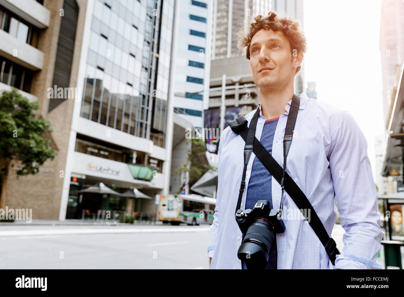 Happy male tourist in city walking with camera Stock Photo - Alamy