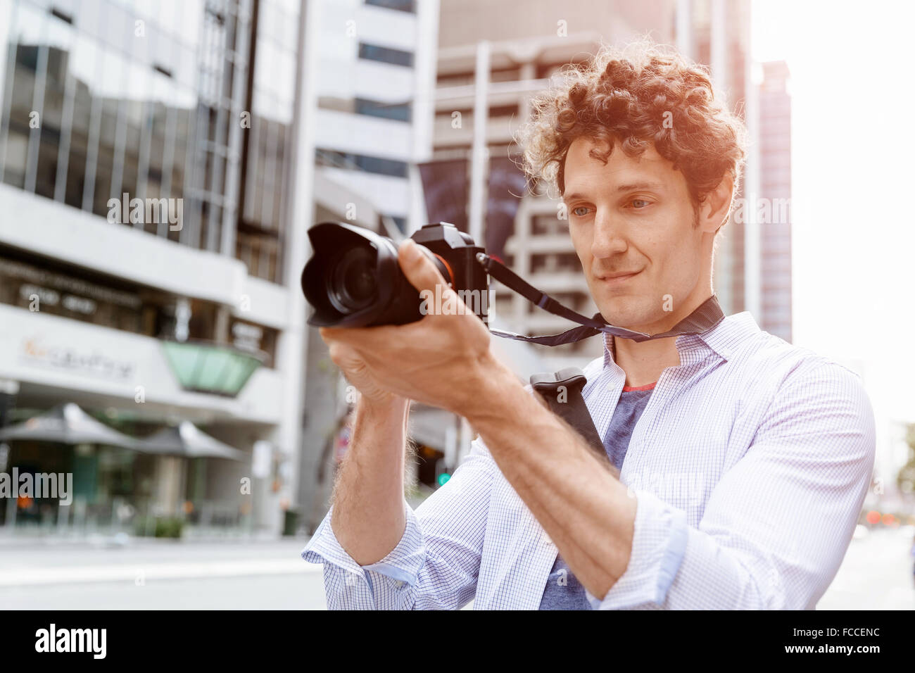 Professional photographer taking picture in city Stock Photo - Alamy