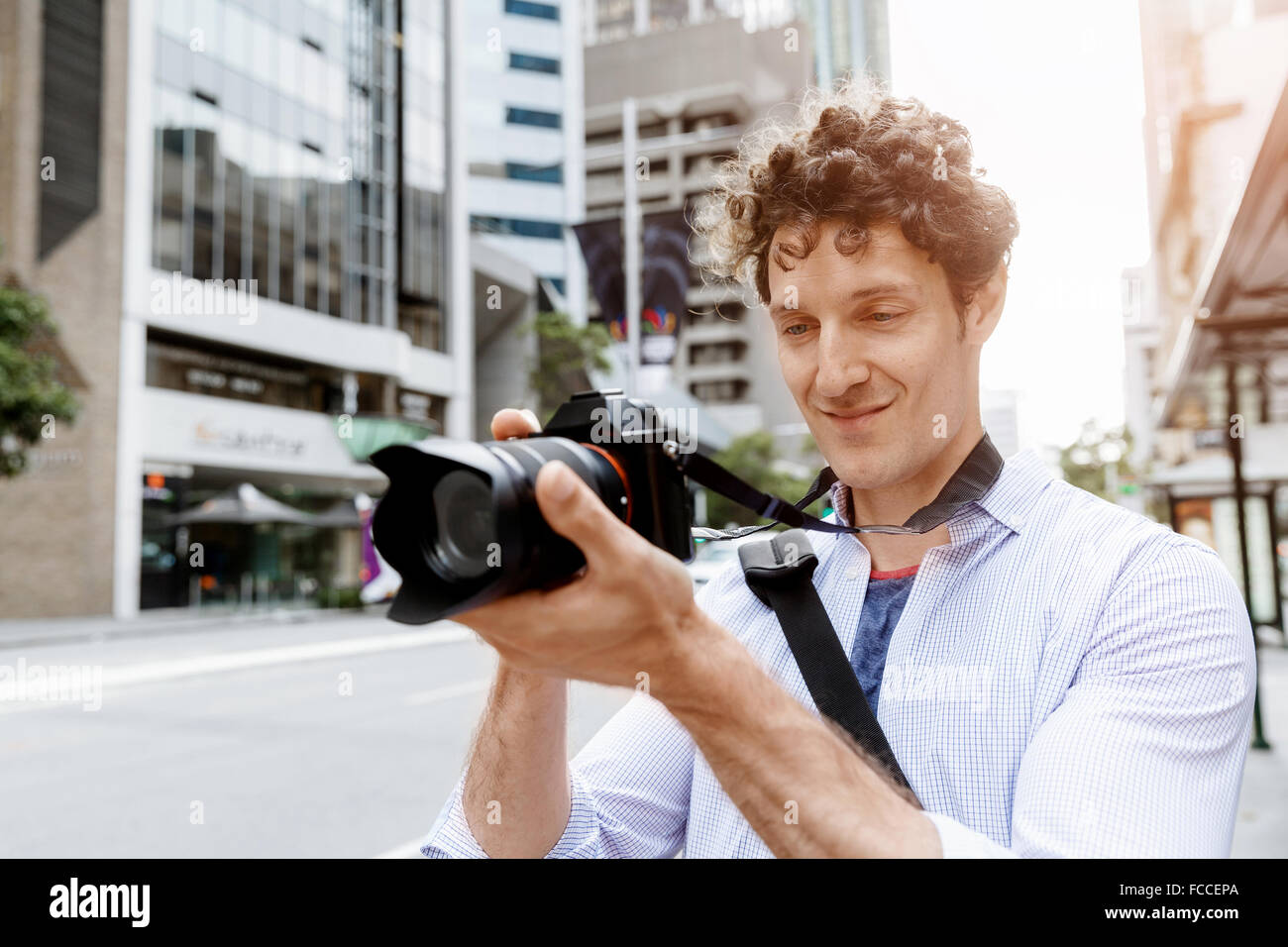 Professional photographer taking picture in city Stock Photo - Alamy