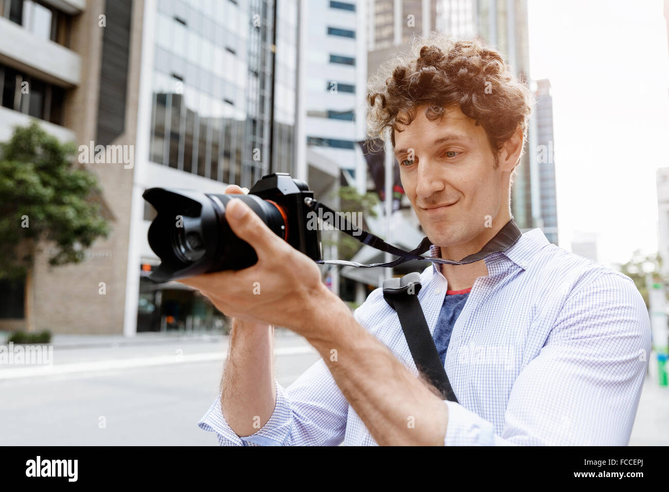 Professional photographer taking picture in city Stock Photo - Alamy
